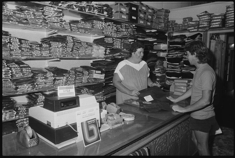Unidentified male customer and female assistant inside workwear store ...